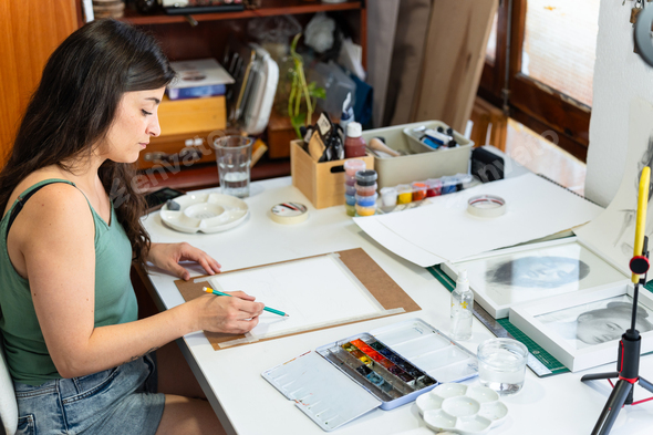 Female illustrator drawing in pencil in her art studio Stock Photo by ...