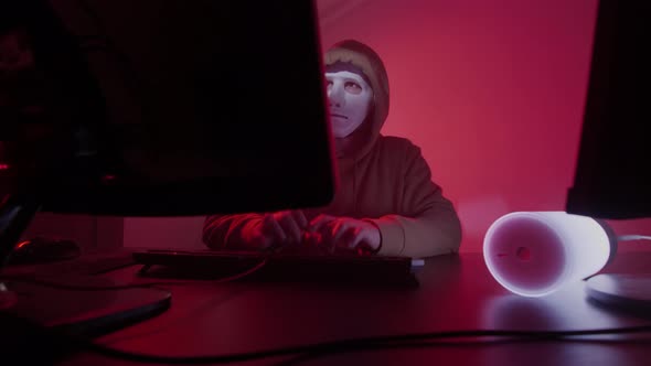 Anonymous Person in a White Mask Works on the Computer Inputs Code ...