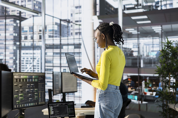 Admin in office using laptop to develop machine learning algorithms Stock Photo by DC_Studio