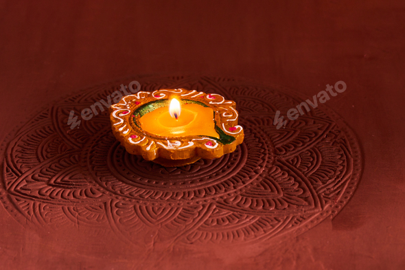 Diwali Diya on Rangoli. A decorative clay diya with a flame Stock Photo ...