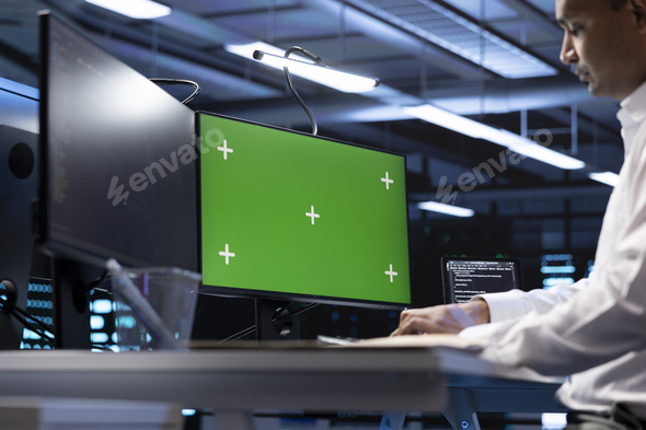 Man in data center using green screen computer to check server performance Stock Photo by DC_Studio