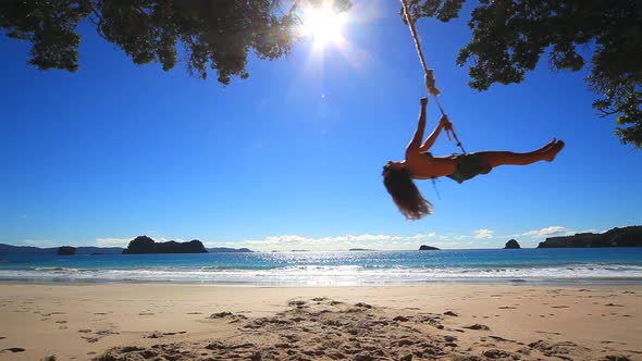 Woman swinging on rope swing by the ocean, Stock Footage | VideoHive