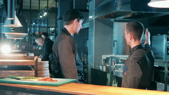 Two Cooks are Talking in the Restaurant Kitchen, Stock Footage | VideoHive