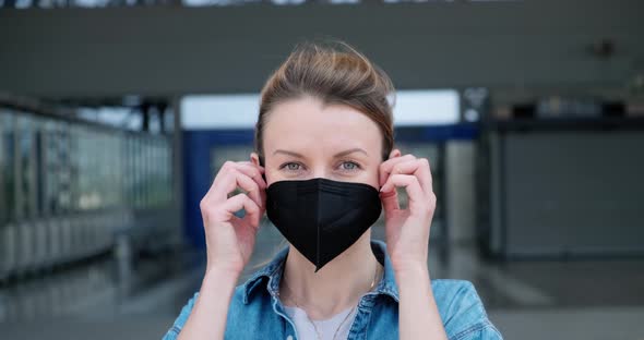 Young woman outdoors taking off protective face mask., Stock Footage
