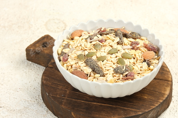bowl of whole grain muesli on white background Stock Photo by edgunn36