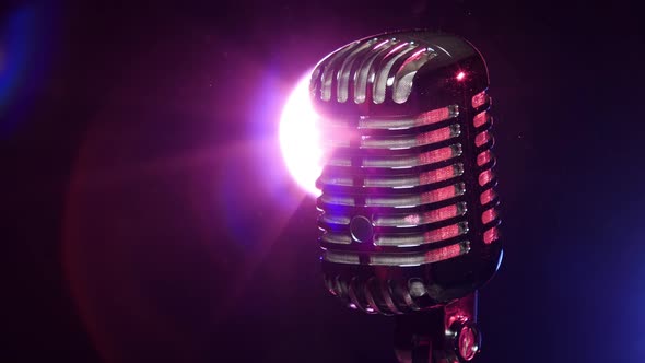 Classic Microphone Slow Rotating on Background Lamp Stroboscope in Dark ...