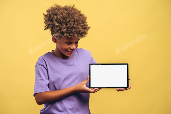 Smiling African American boy holding digital tablet with empty, white ...