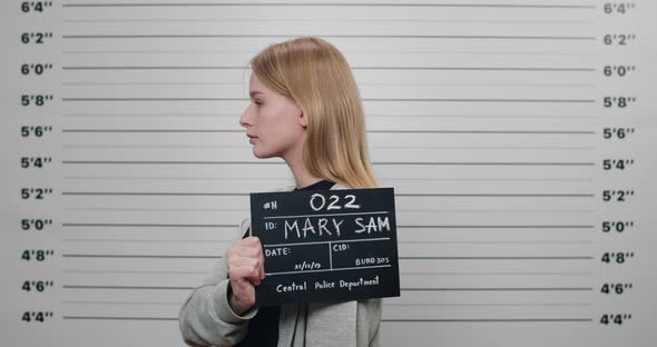 Mugshot of Young Criminal Woman Holding Sign for Photo in Police ...