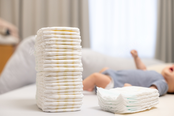 Adorable Newborn Baby with Stacked Diapers Stock Photo by leungchopan