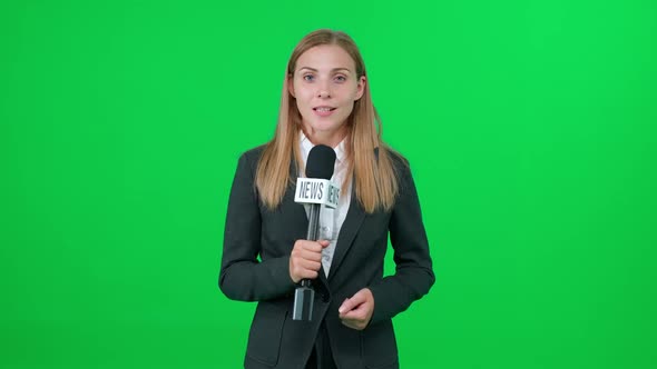 Breaking News Female News Reporter Speaks Into a Microphone on a Green ...