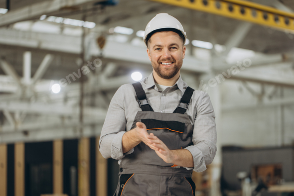 Smiling engineer clapping hands in modular building factory Stock Photo ...