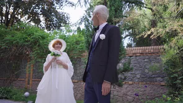 Excited Groom with Grey Hair Admiring Happy Bride Standing at ...