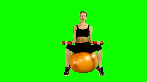 Sport Sitting on Pilates Ball and Exercising with Dumbbells. Green ...