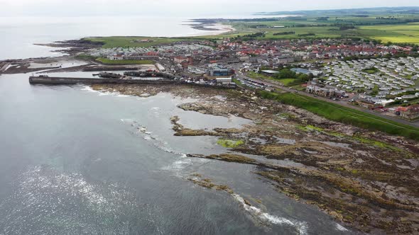 Aerial footage of the seaside coastal town of the village of Seahouses ...