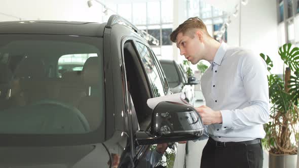 A Car Dealership Employee Inspects the Car To Describe the Set-up ...