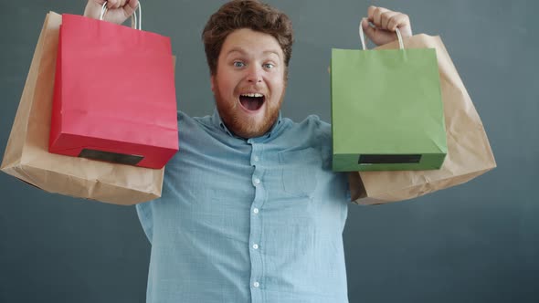Portrait of Guy Shopaholic Holding Shopping Bags and Smiling Looking at ...