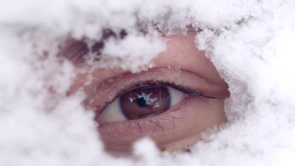 a Closeup of the Female Eye Peeps Out From Under the Snow, Stock Footage