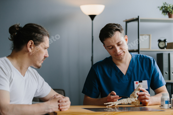 Doctor explaining a foot anatomy procedure to a patient using a ...