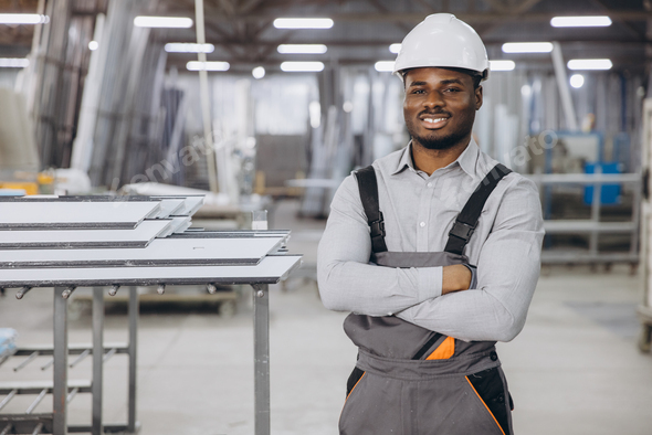 Factory worker posing with arms crossed in windows and doors production ...