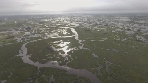 Aerial view or river affluents in flooded area with sun reflection in ...