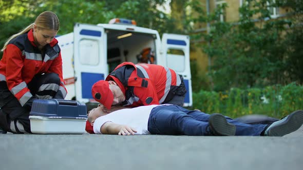 Paramedics Helping Unconscious Man Lying on Road, Making Injection With ...