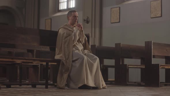 Priest Sitting on Wooden Bench in Church Praying, Stock Footage | VideoHive