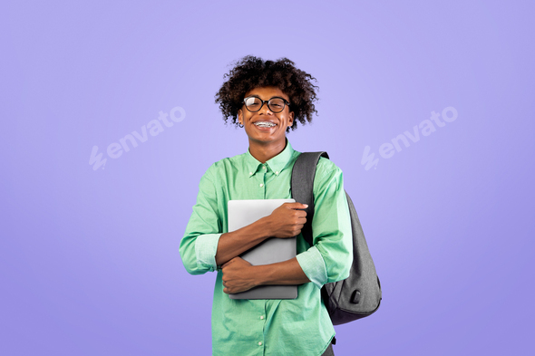 Student's lifestyle concept. Happy african american guy holding laptop ...