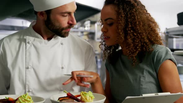 Chef carrying food plates interacting with restaurant manager, Stock ...