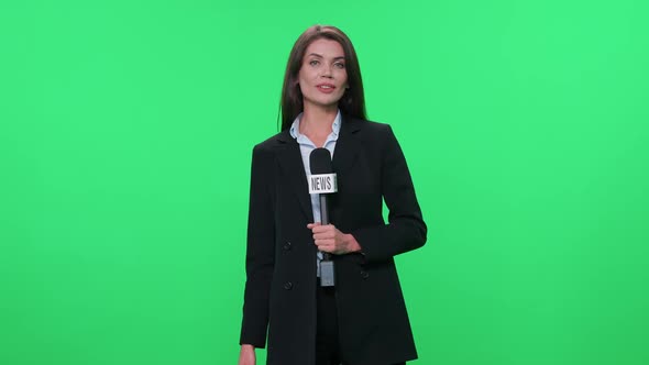 Female Reporter in Suit Looks at the Camera and Speaks Into a ...