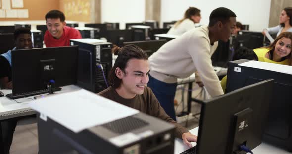 Young multiracial students using computer inside classroom at ...