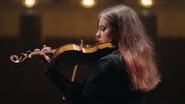 Young Female Violin Player is Practicing to Play Violin in Music Hall ...