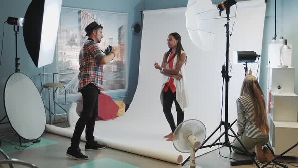 Backstage of the Photo Session in Modern Studio Assistant Adjusting the ...