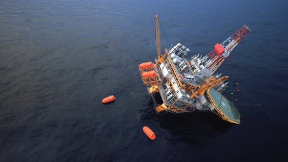 Collapsed offshore oil platform. Floating lifeboats in the sea. Oil ...
