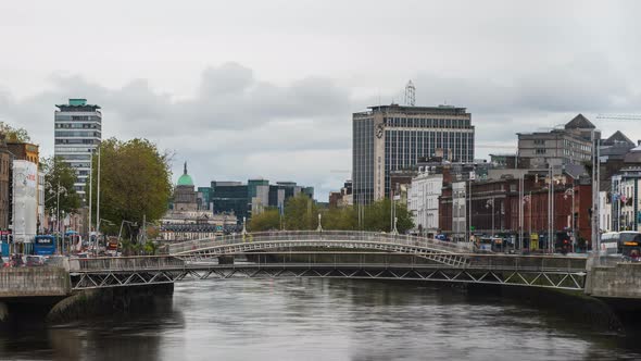 Time lapse of Liffey river with people crossing the bridge and daytime ...