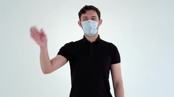 Handsome Young Man Wearing a Medical Mask Looks at the Camera and ...