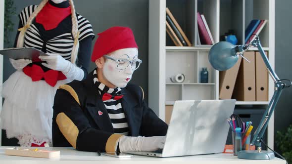 Mime Businessman Using Laptop While Girl Secretary Bringing Document To ...