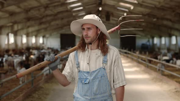 Farmer Carrying Pitchfork While Walking at Stable with Goats, Stock Footage