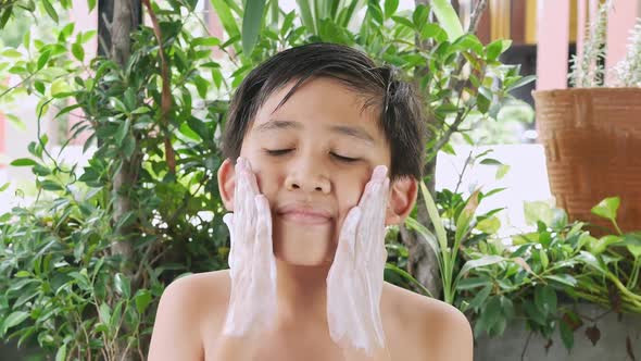 Asian boy is cleaning his face with a foaming cleanser., Stock Footage
