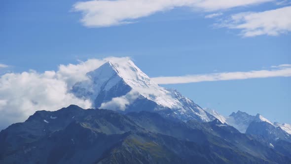 Ice capped Mount Cook Summit; time lapse withing clouds on a sunny day ...