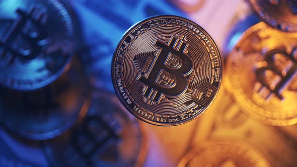 Golden Bitcoin Coins are Rotating on a Dollar Banknotes Background ...