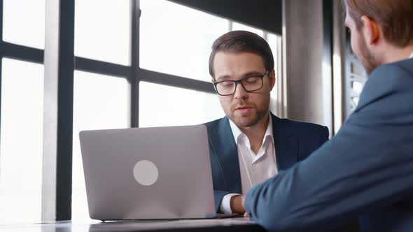 Young professional in a suit interviewing a man at the desk, Stock Footage