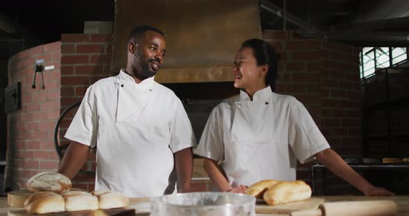 Animation of two diverse male and female bakers smiling at camera in ...