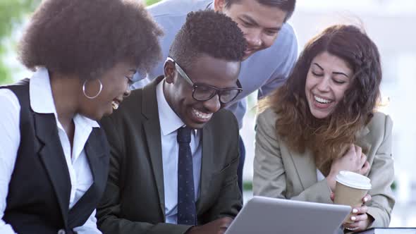 Colleagues Watching Video on Laptop and Laughing Outdoors, Stock Footage