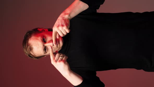 The Man Gives Signals with His Hands Against the Background of Red ...