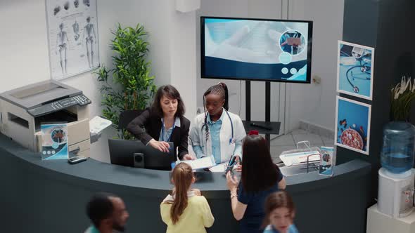 Secretary Working at Busy Hospital Reception Desk to Help Patients ...