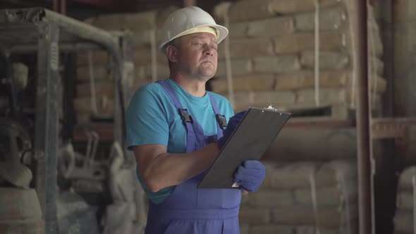 Professional Foreman Filling in Documents Standing in Factory Warehouse ...