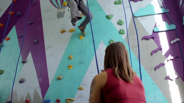 Female Instructor Lowering Teenage Boy from Climbing Wall on Rope ...