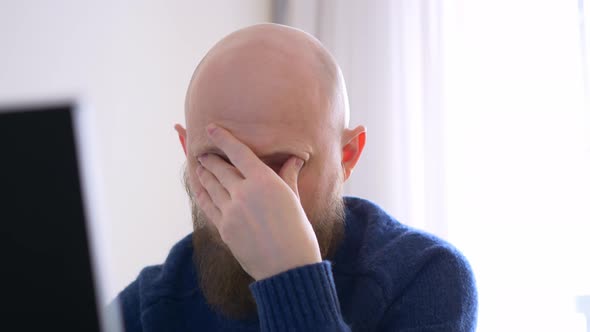 Tired Man Behind a Computer Screen Rubs His Red Eyes and Yawns From ...