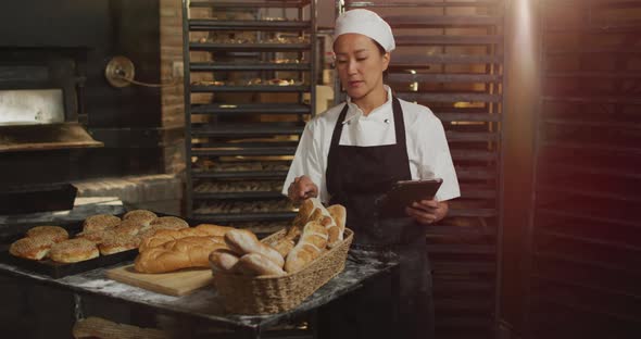 Animation of asina female worker using tablet and counting breads ...
