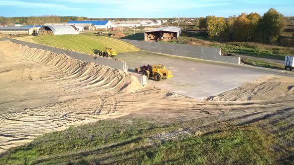 Aerial Flight Over Huge Silage Pits with Operating Machinery, Stock Footage